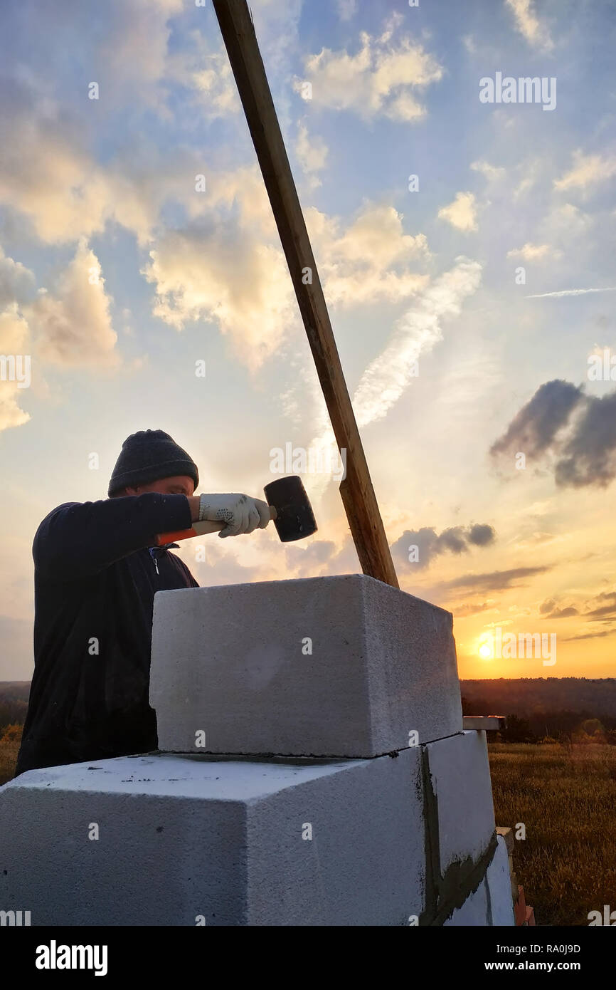 The master uses a rubberized hammer to level the blocks during the ...
