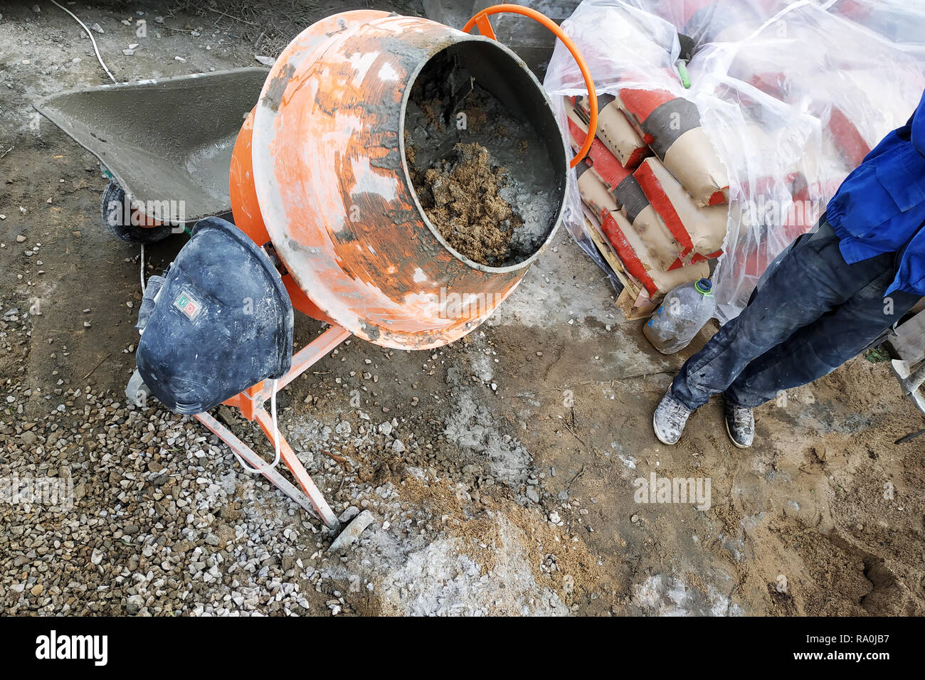 auxiliary worker uses a shovel to prepare a cement mortar on a ...