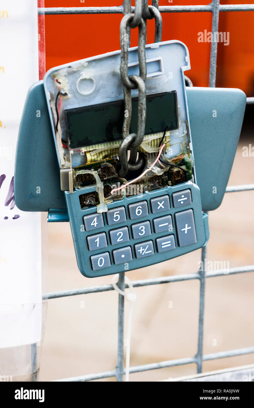 broken calculator hanging on a fence Stock Photo - Alamy