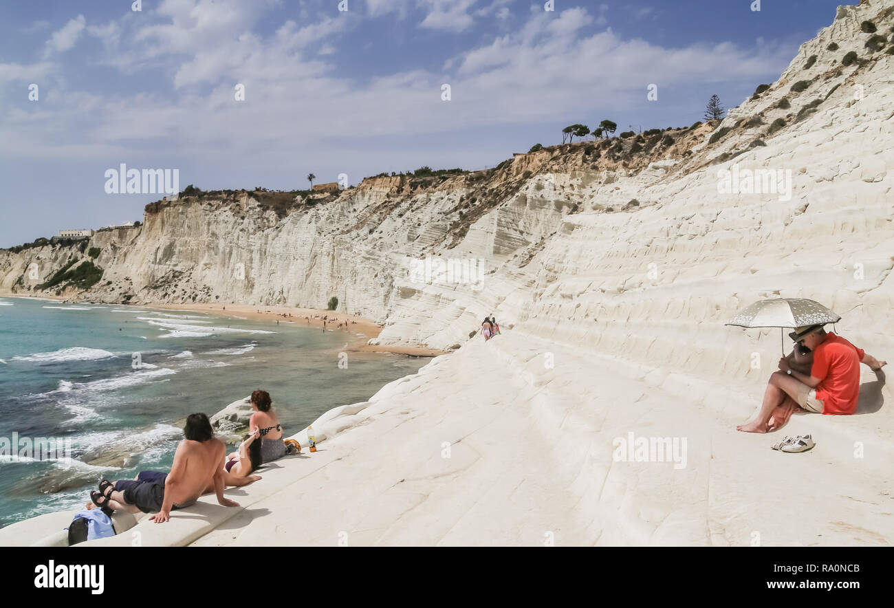 Unidentified peoplel sits on a slope of white cliff called "Scala dei ...