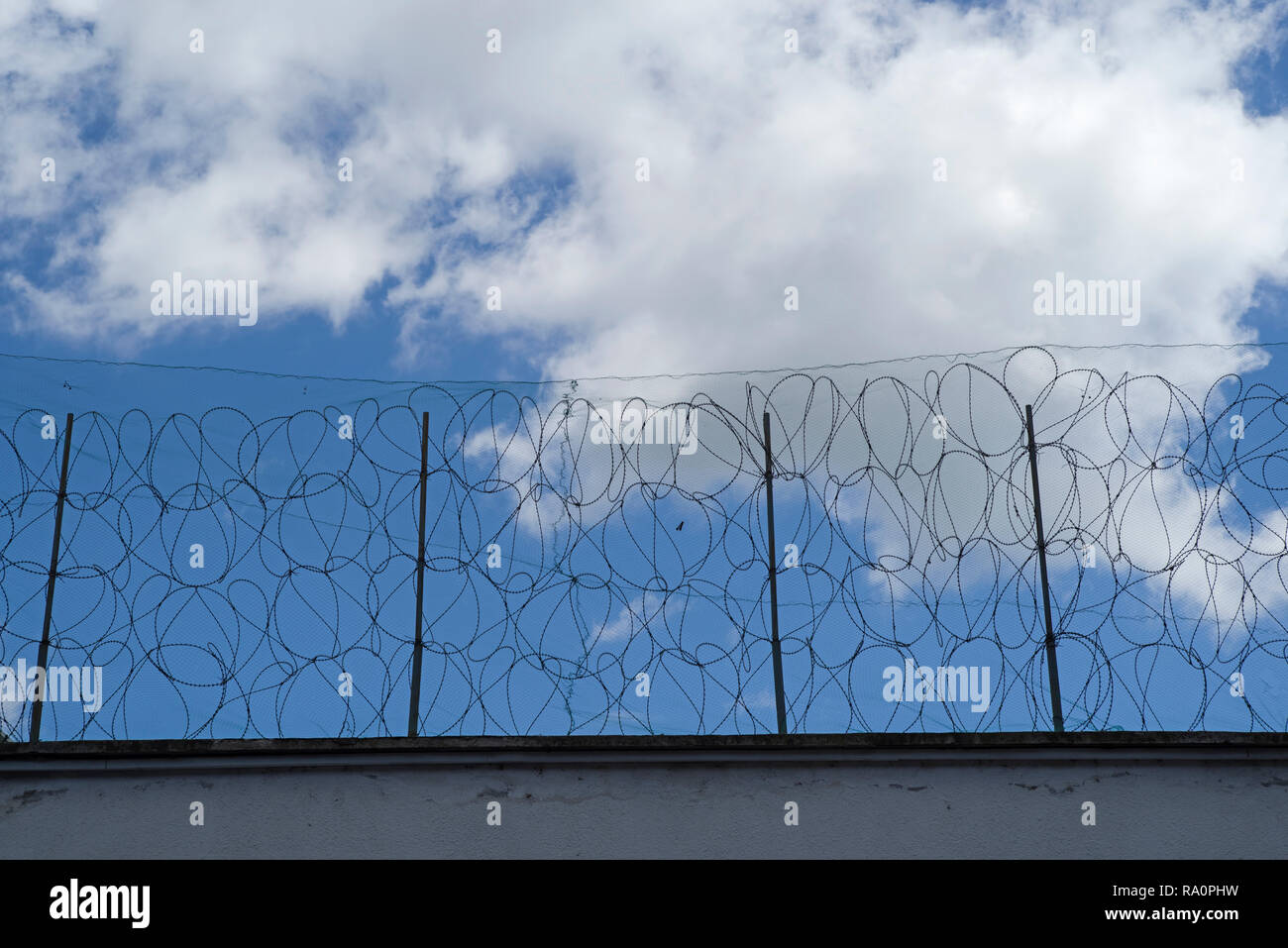 Prison wall and fence, barbed wire arround prison walls Stock Photo - Alamy