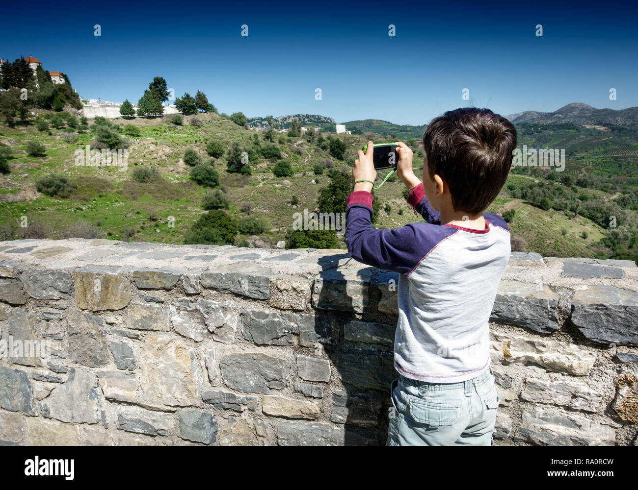 Rear view of boy photographing landscape Crete Greece Stock Photo - Alamy