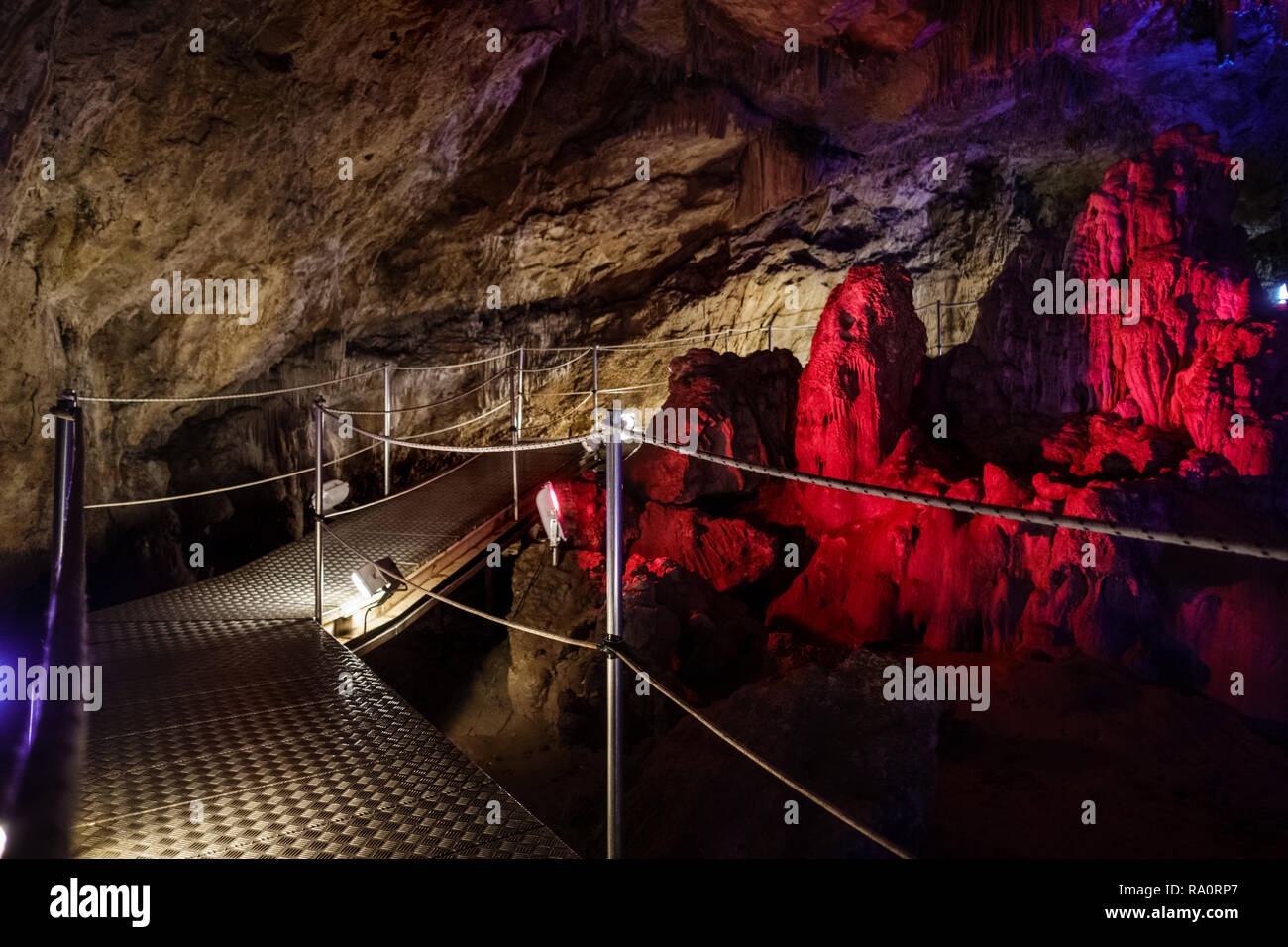 Footbridge in illuminated stone cave Crete Greece Stock Photo - Alamy