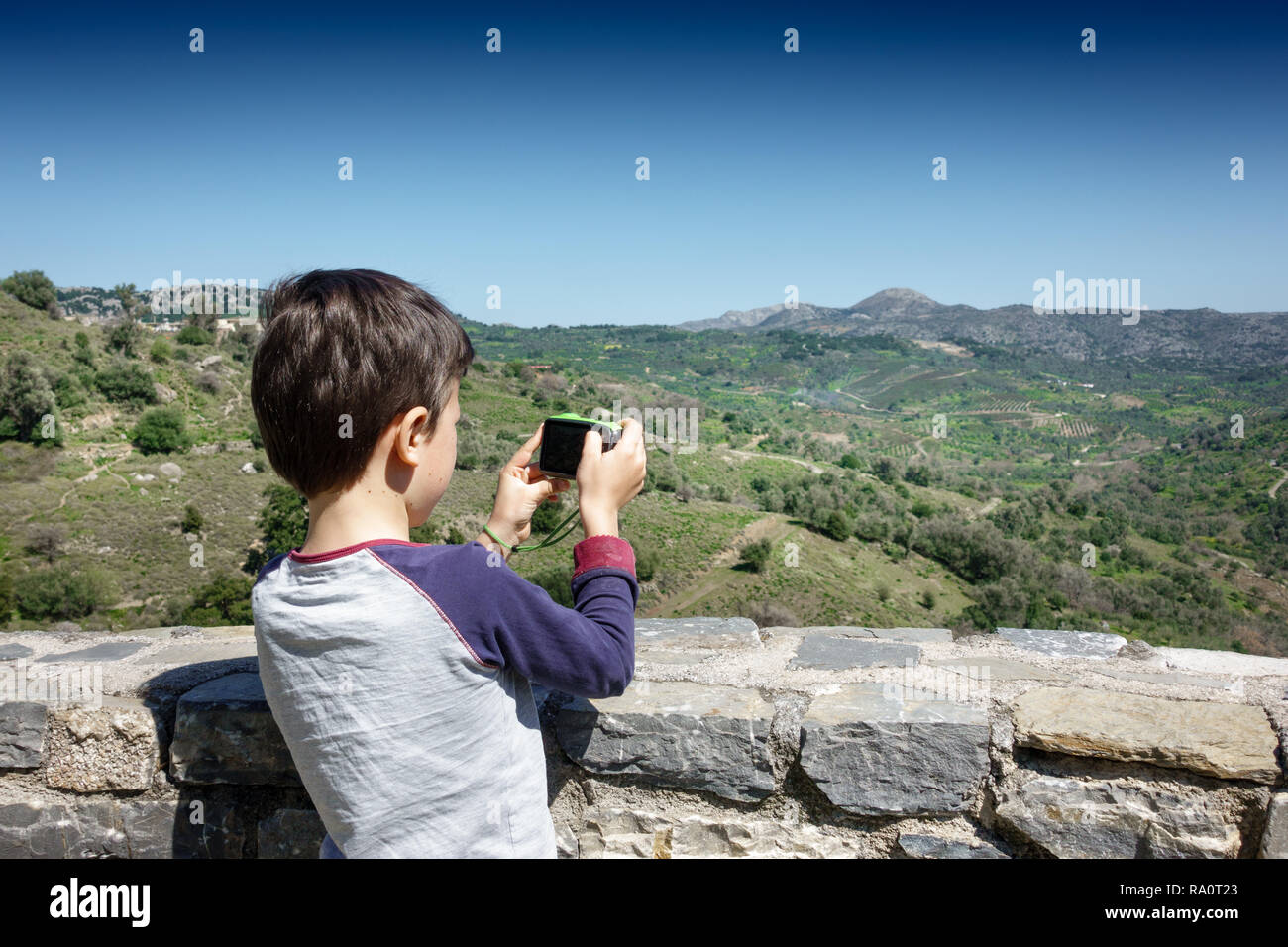 Rear view of boy photographing landscape Crete Greece Stock Photo - Alamy