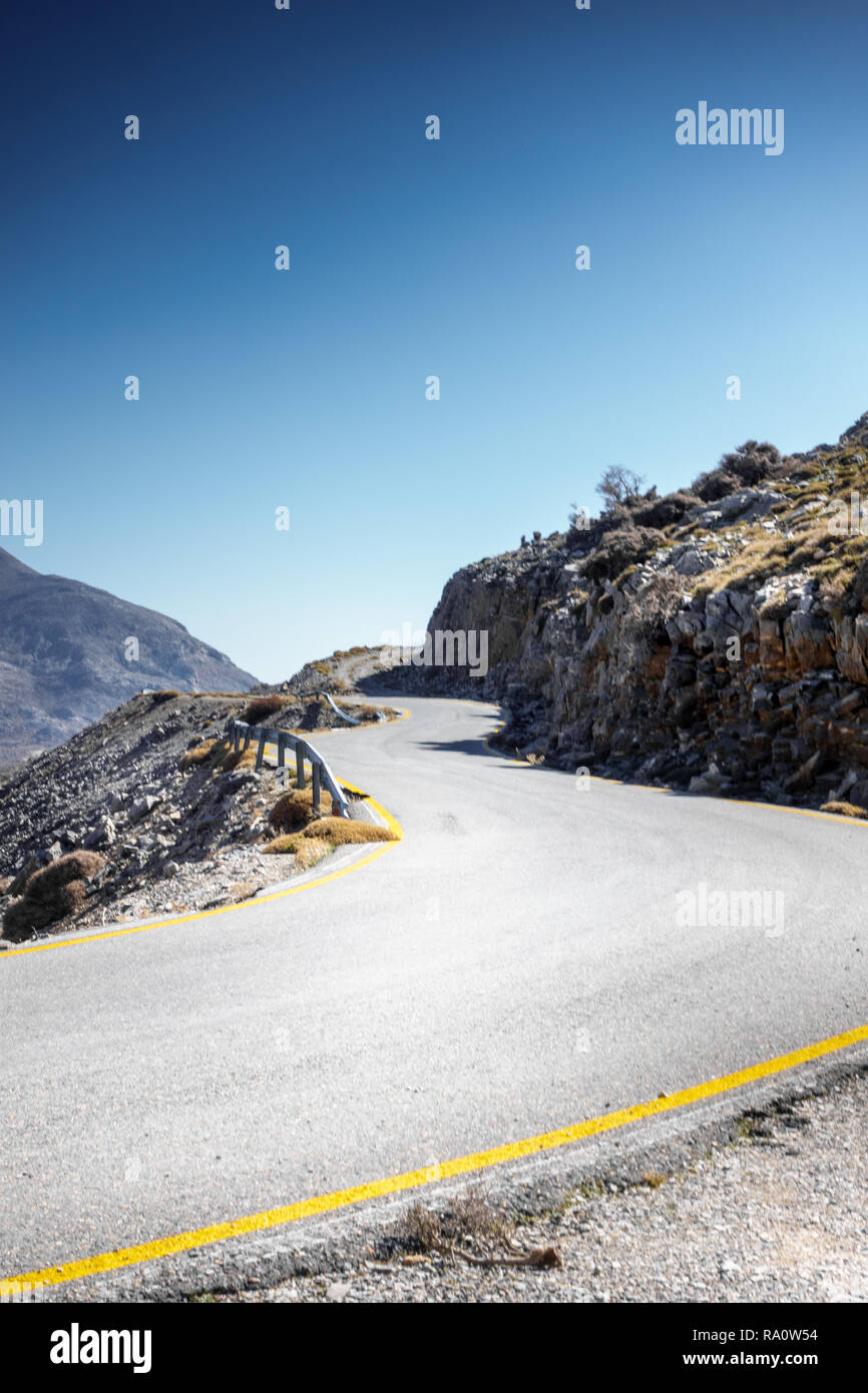 View of curvy single lane road in extreme terrain Crete Greece Europe ...