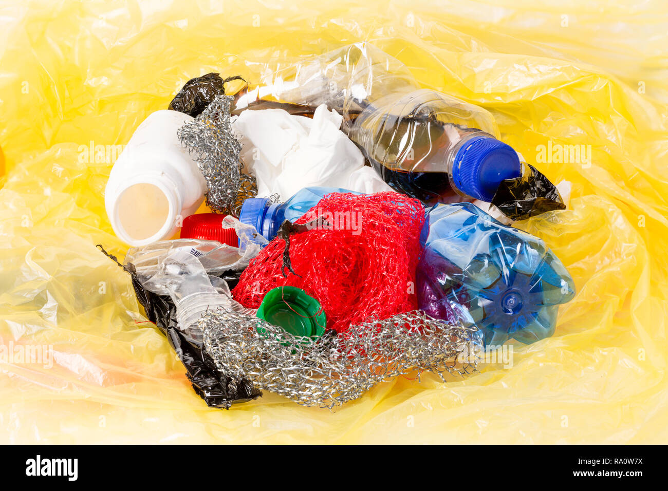 Plastic garbage with empty plastic bottles and other rubbish on yellow ...