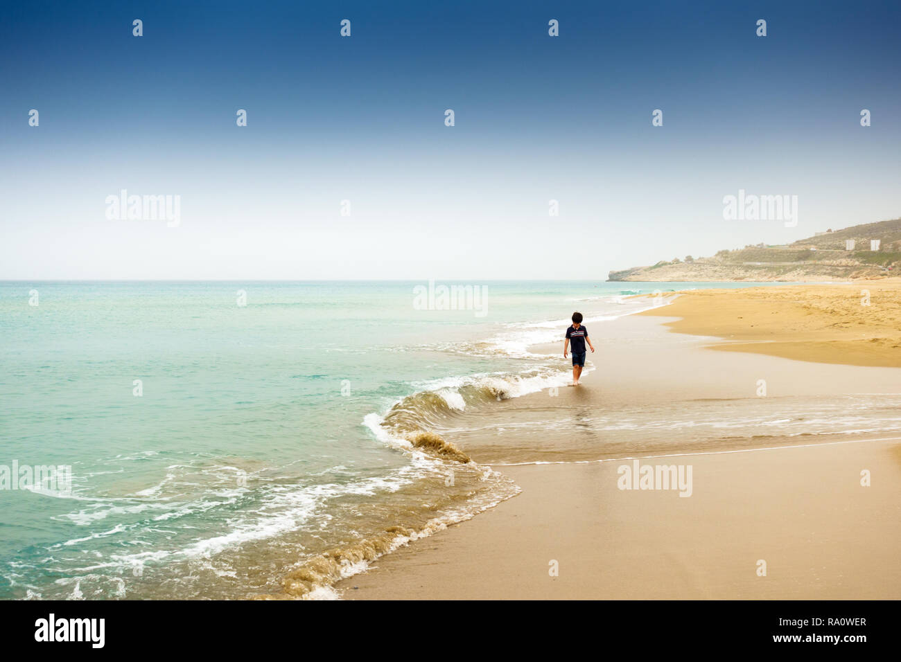 Boy walking on sea shoreline Crete Greece Europe Stock Photo - Alamy