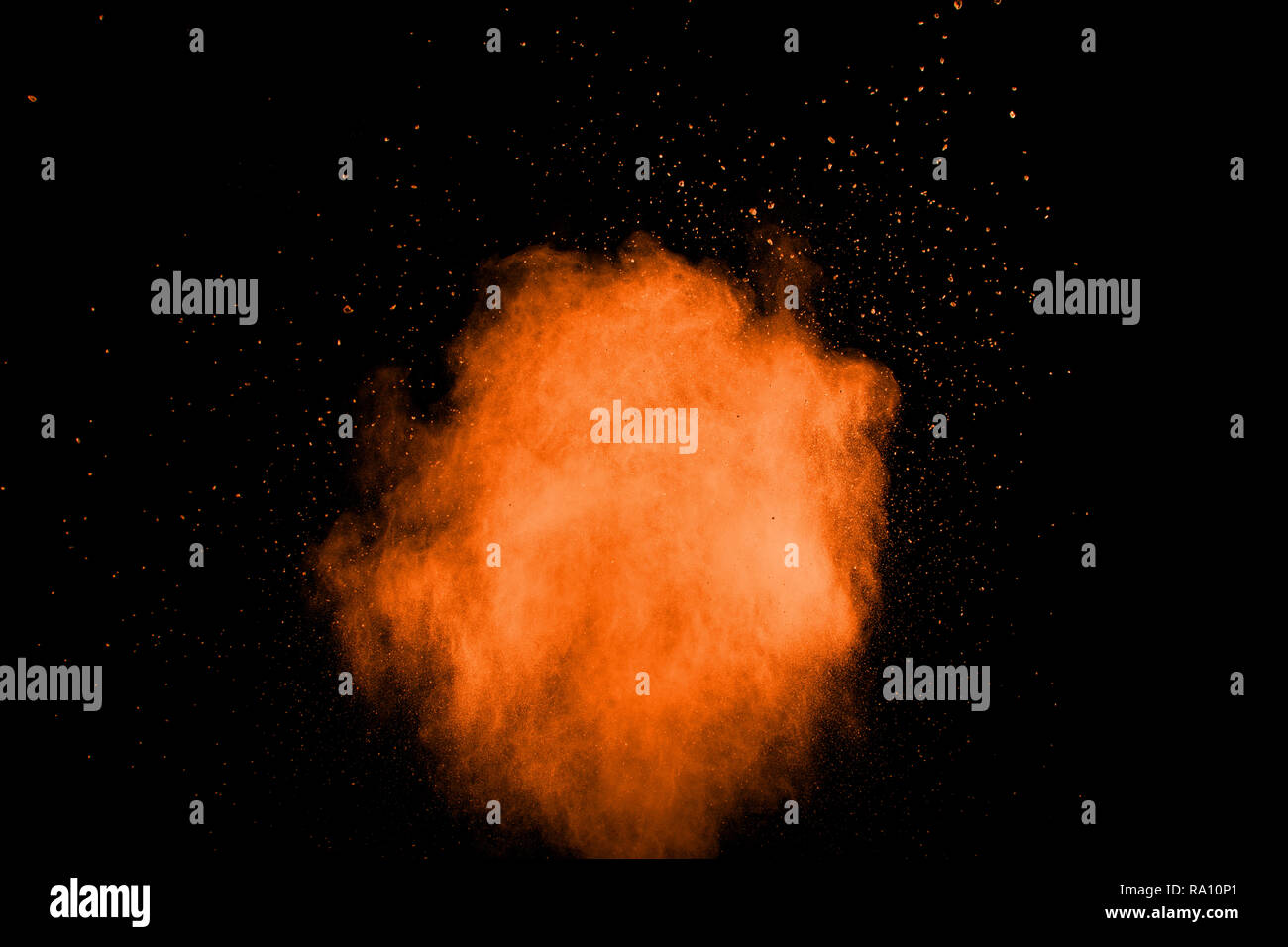 Abstract orange powder explosion on black background. Freeze motion of ...