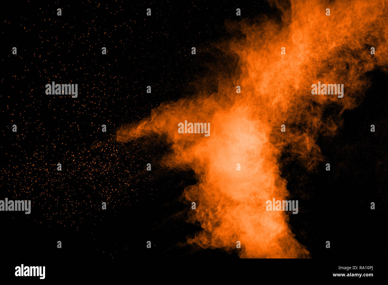 Abstract orange powder explosion on black background. Freeze motion of ...