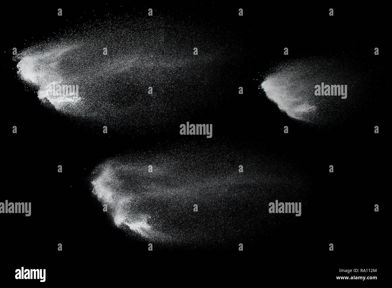 Freeze motion of white dust particles on black background. White powder ...