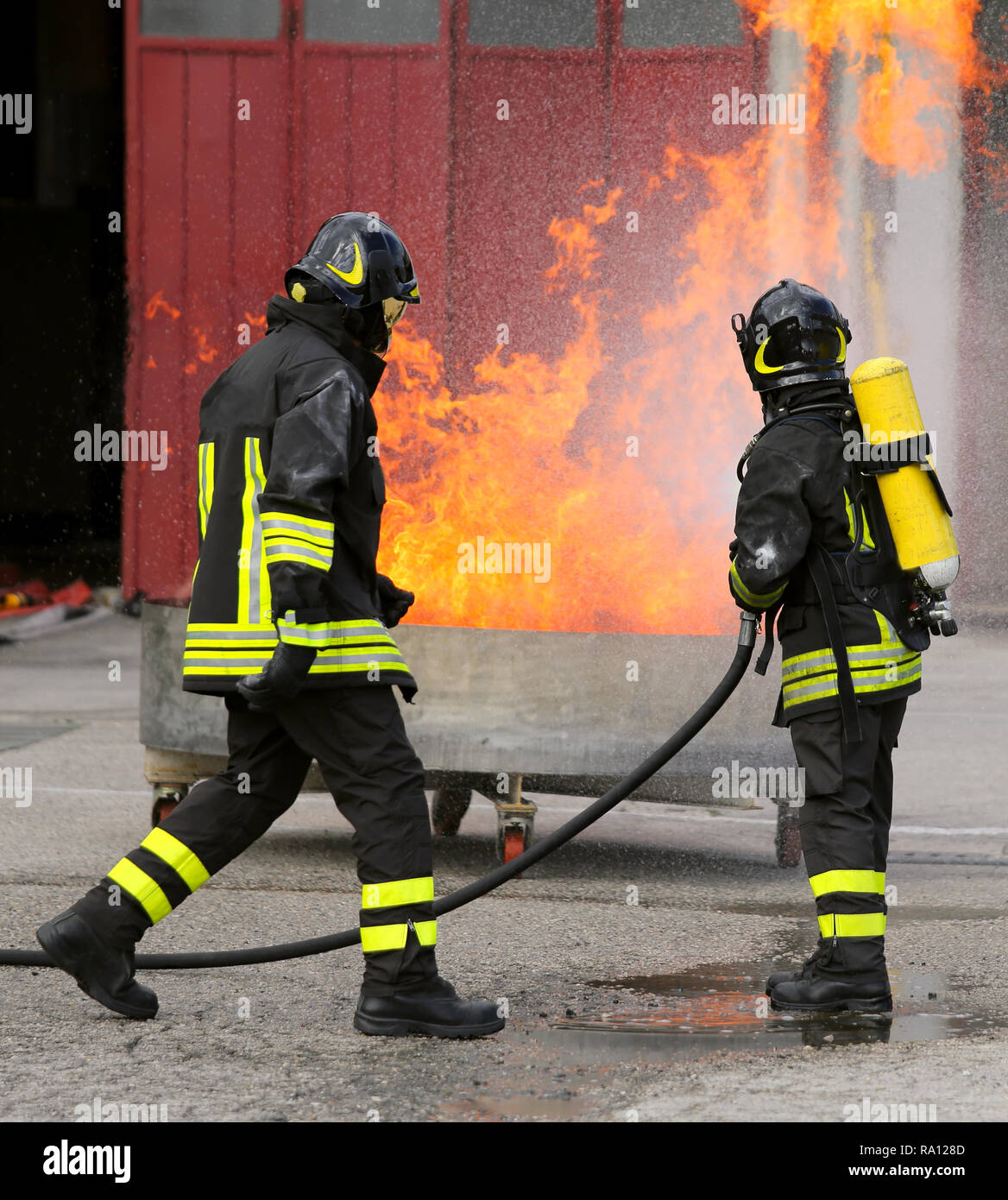 two intrepid firefighters during the exercise with a tank full of ...
