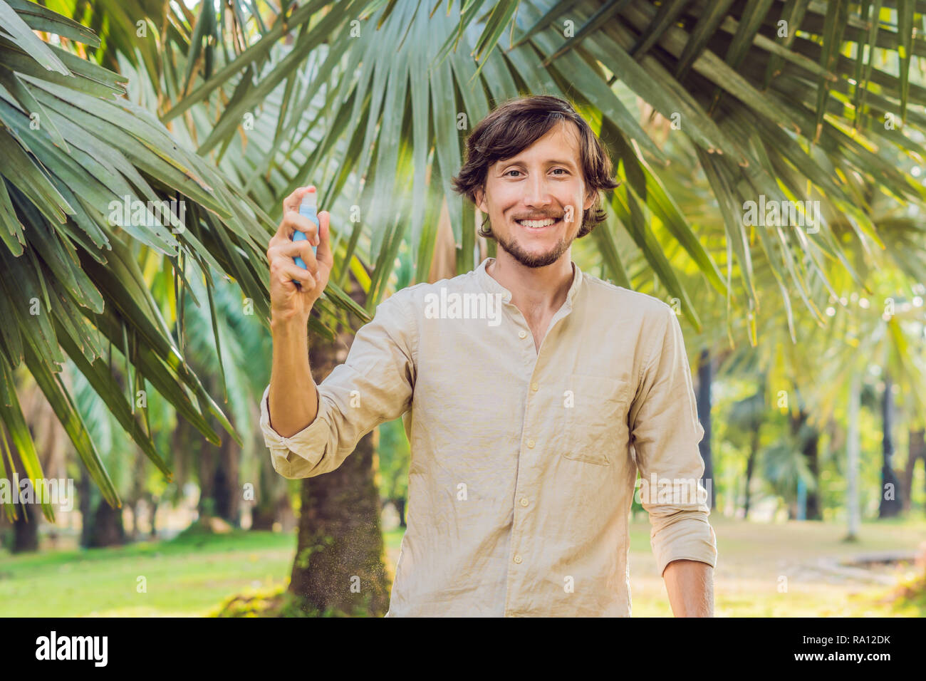 Young man spraying mosquito insect repellent in the forrest, insect ...