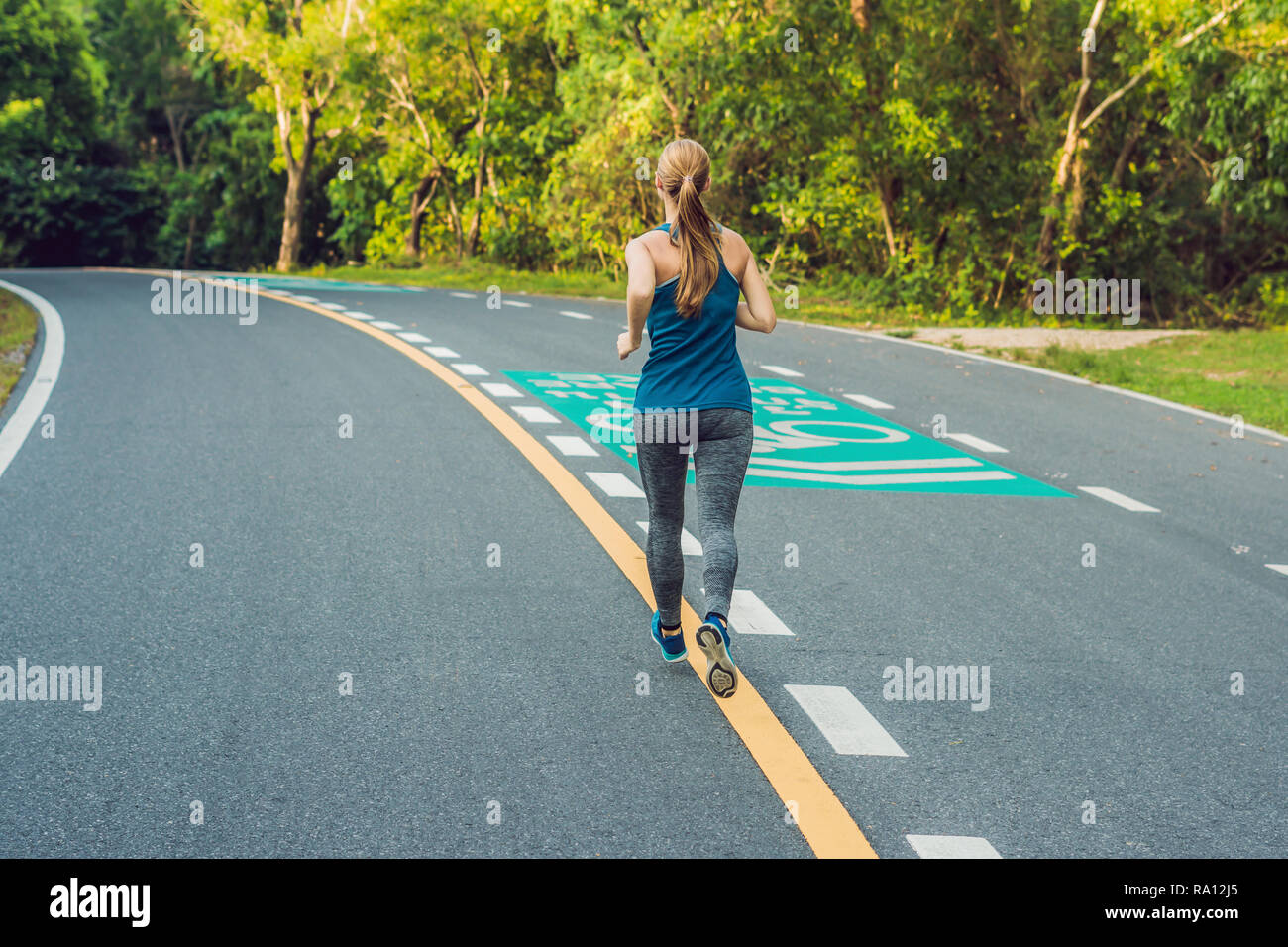 Sporty woman running on road at sunrise. Fitness and workout wellness ...