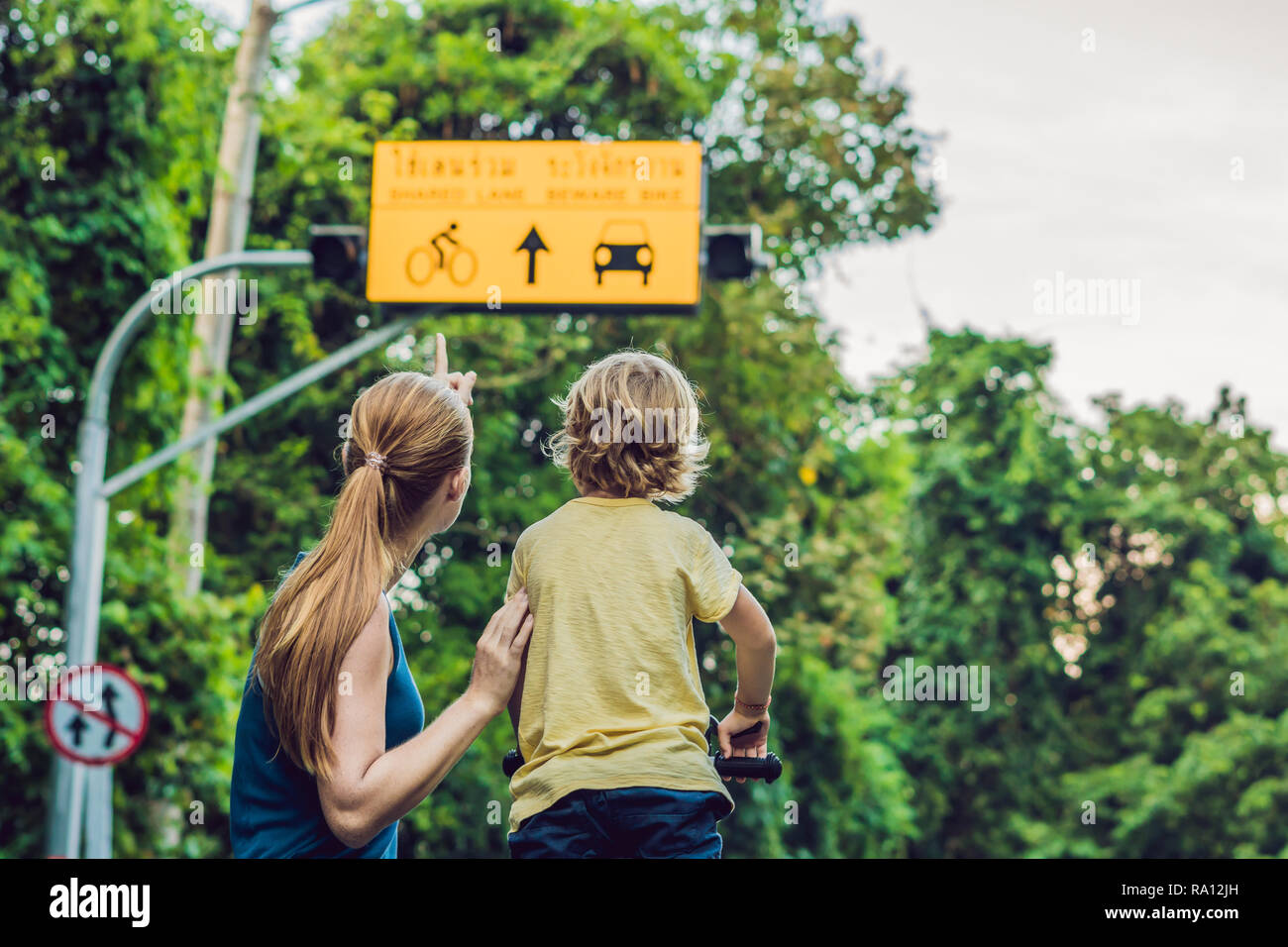 Mom shows his son a plate of shared lane and beware bike warning sign ...