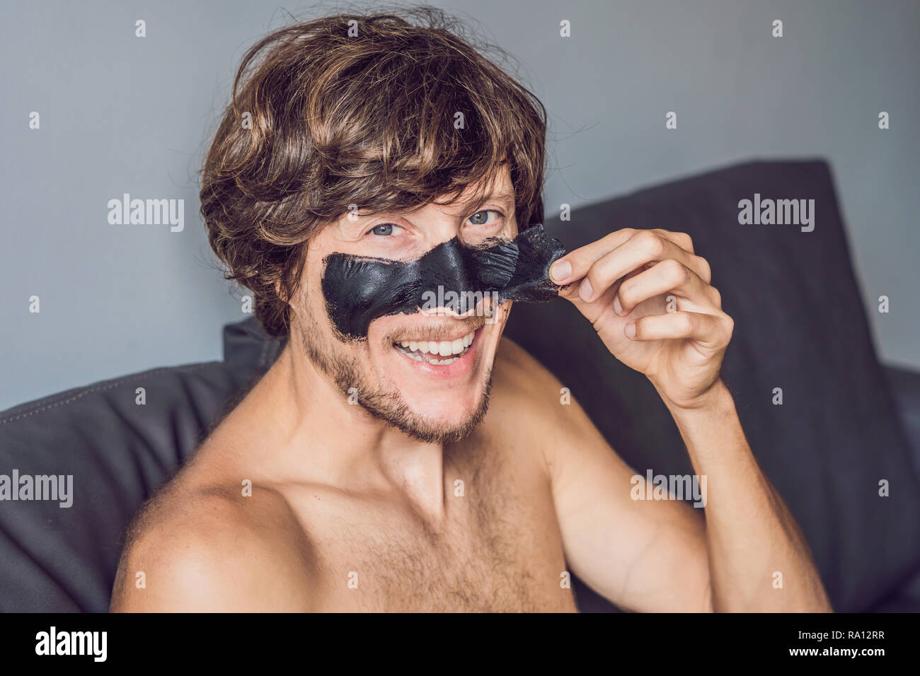 Happy man with black mask on the face. Photo man receiving spa ...