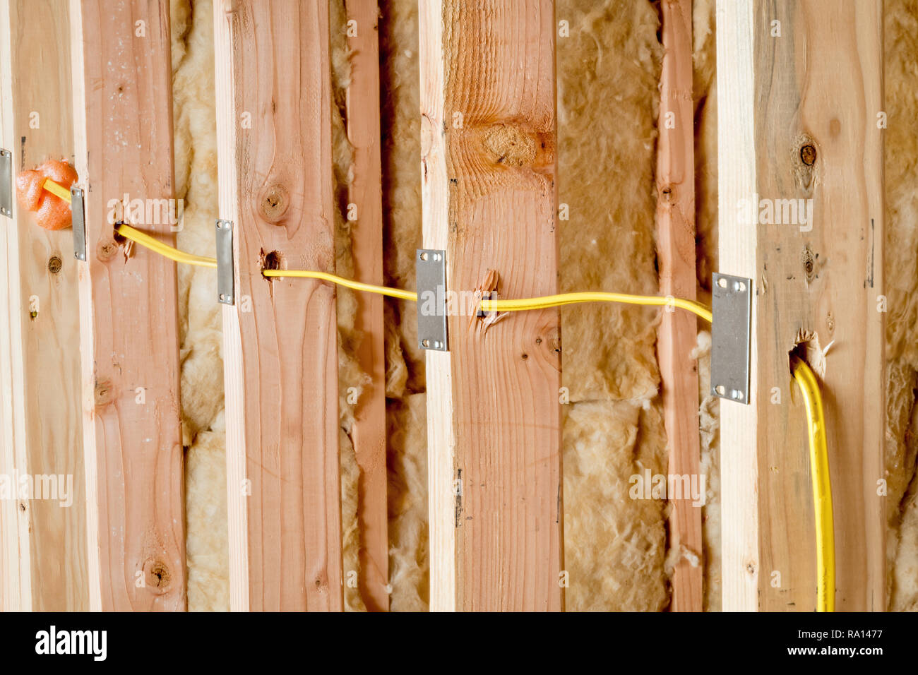 Metal plates protect electrical wire in wood studs of a home under ...