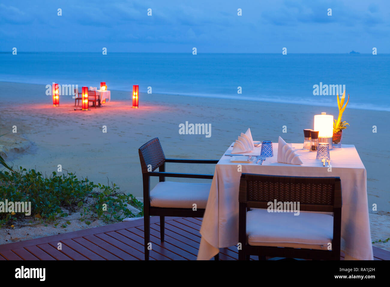 Table setting. Resort cafe on the tropical sea beach with beautiful ...