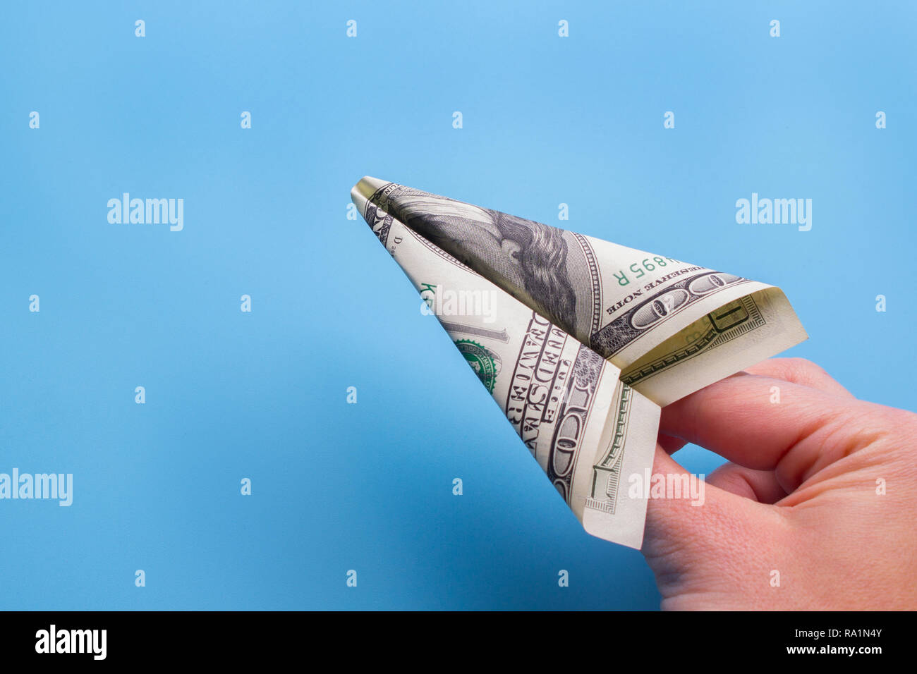 Flying paper plane with dollar banknote holding in hand Stock Photo - Alamy