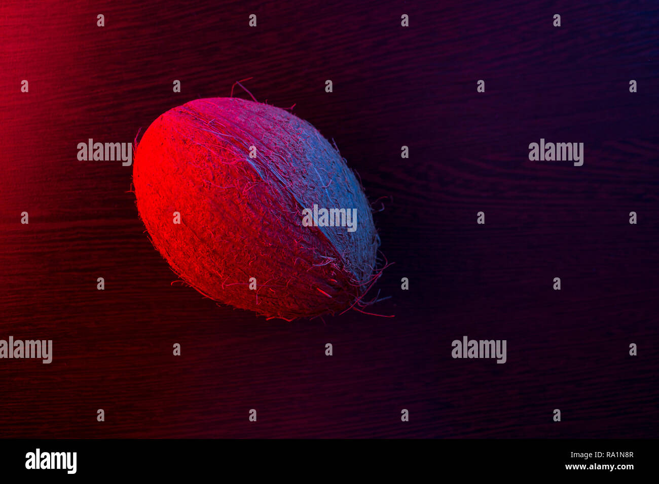 coconut on dark background in neon light Stock Photo - Alamy