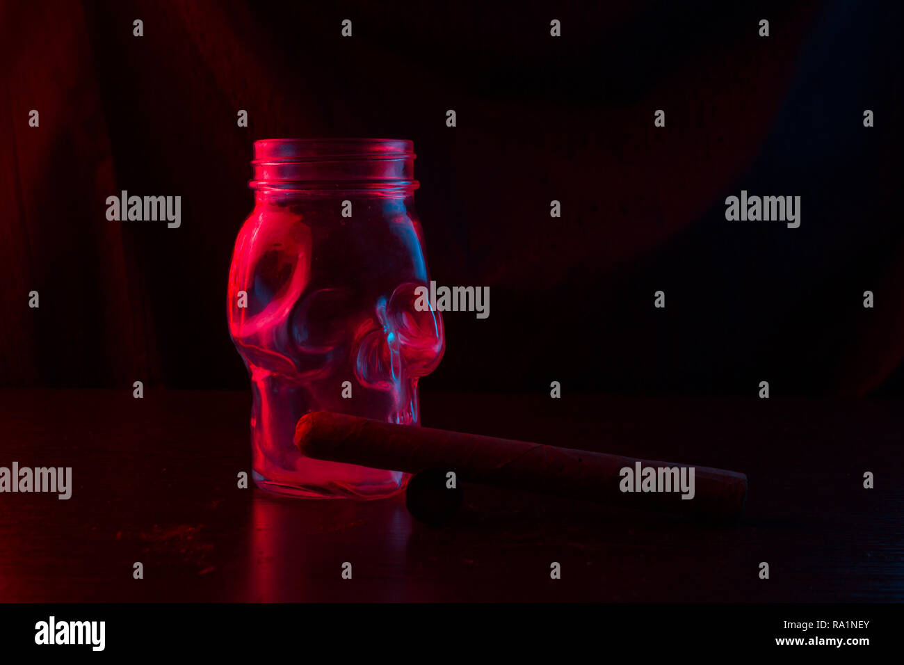 The glass skull smokes a pipe. neon light Stock Photo - Alamy