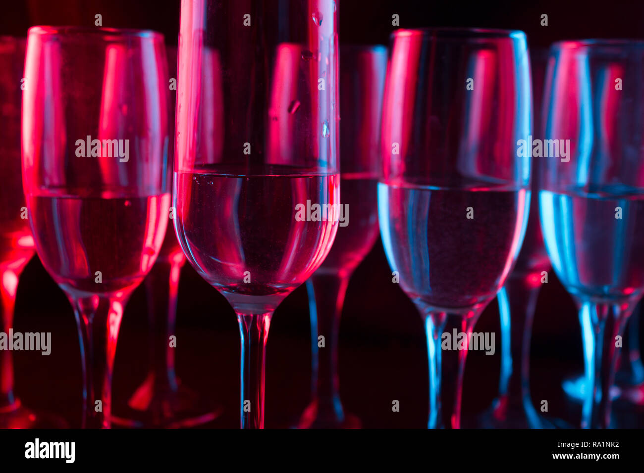 many glasses in neon light. party concept Stock Photo - Alamy