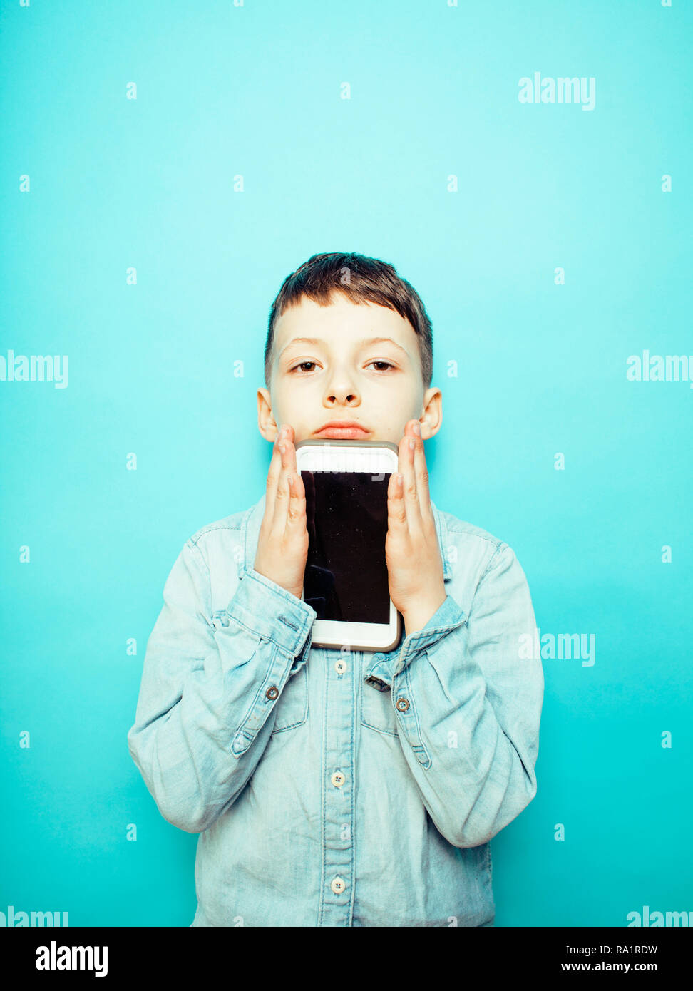little cute boy posing emotional on blue background with smartph Stock ...