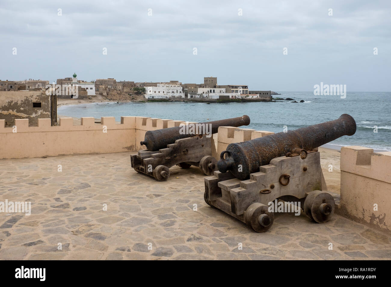 Two old cannons facing towards the Arabian Sea at Mirbat Castle in ...