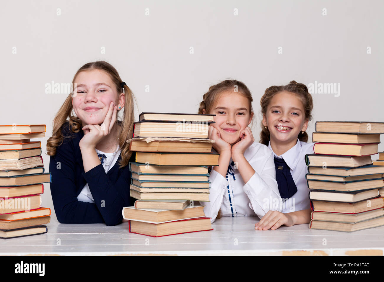 two girls schoolgirls sit with books at his desk on the lesson at ...