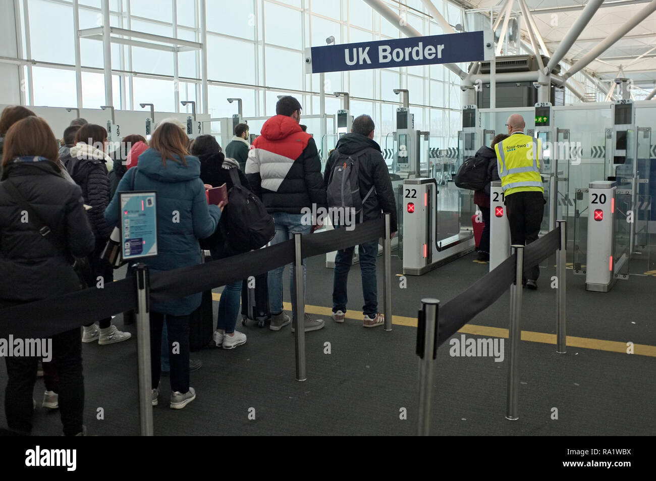 people travelling and queuing at electronic UK BORDER passport control, at stansted airport ...