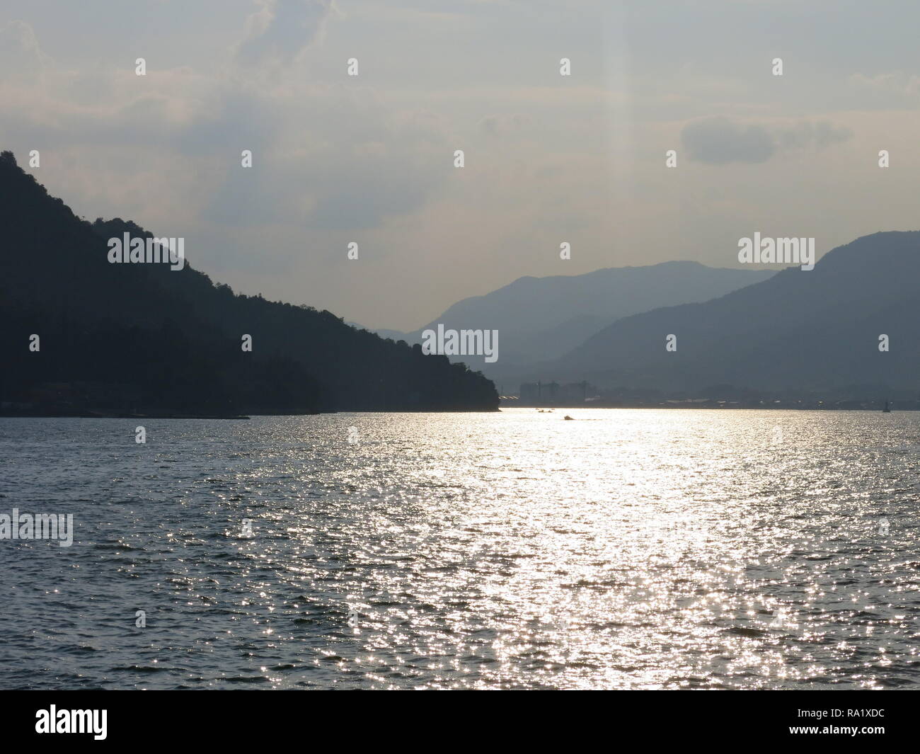 Romantic view of dappled water and distant hills whilst sailing across ...