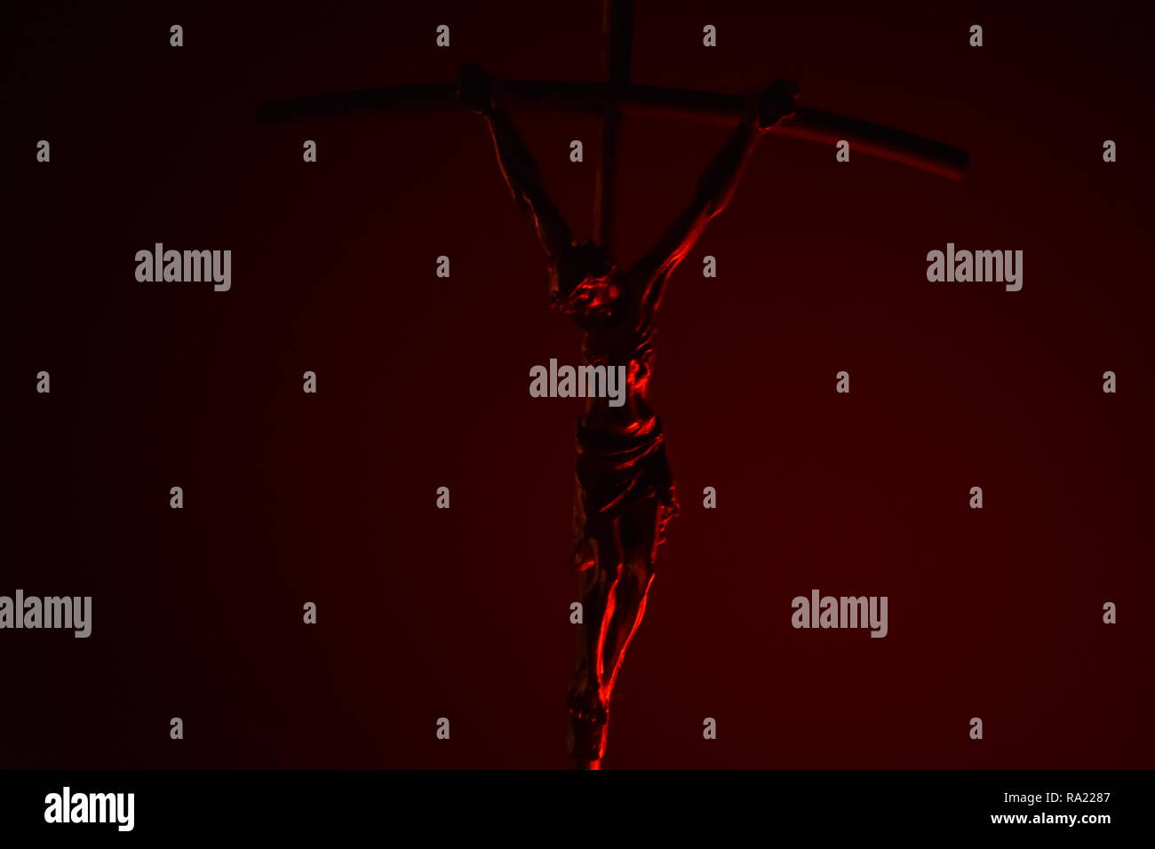 Crucifix on red light Stock Photo - Alamy