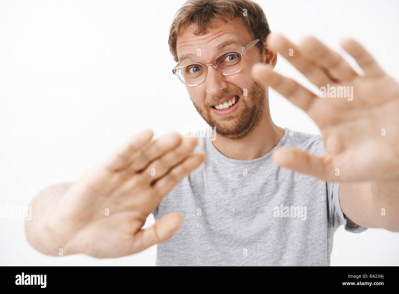 Man feeling shy hates being photographed pulling hands towards camera ...