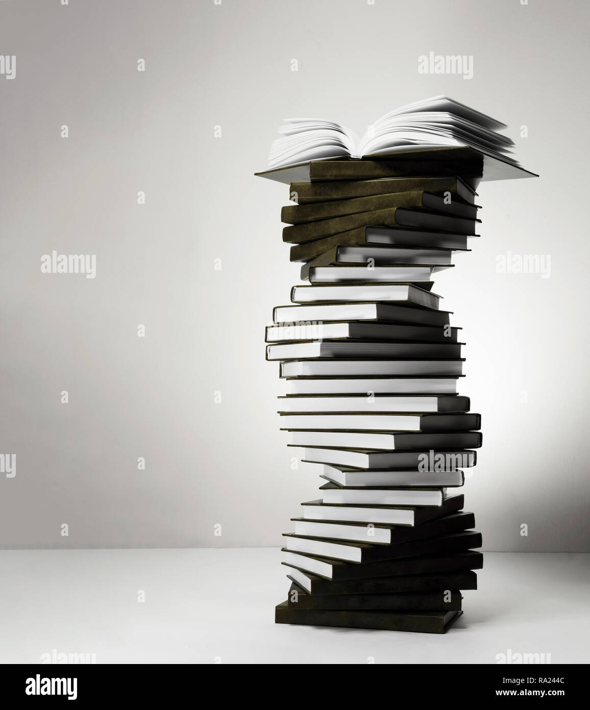 A spiral of stacks of books in the form of DNA and an open textbook at ...