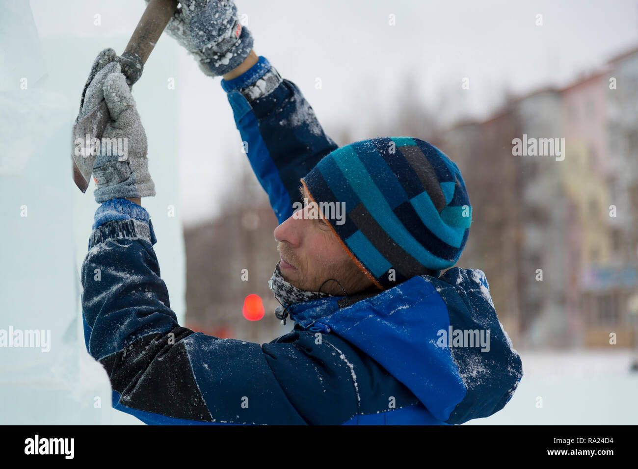 The sculptor cuts an ice figure for Christmas from a block of ice with ...