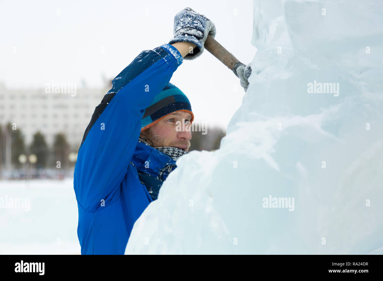The sculptor cuts an ice figure for Christmas from a block of ice with ...