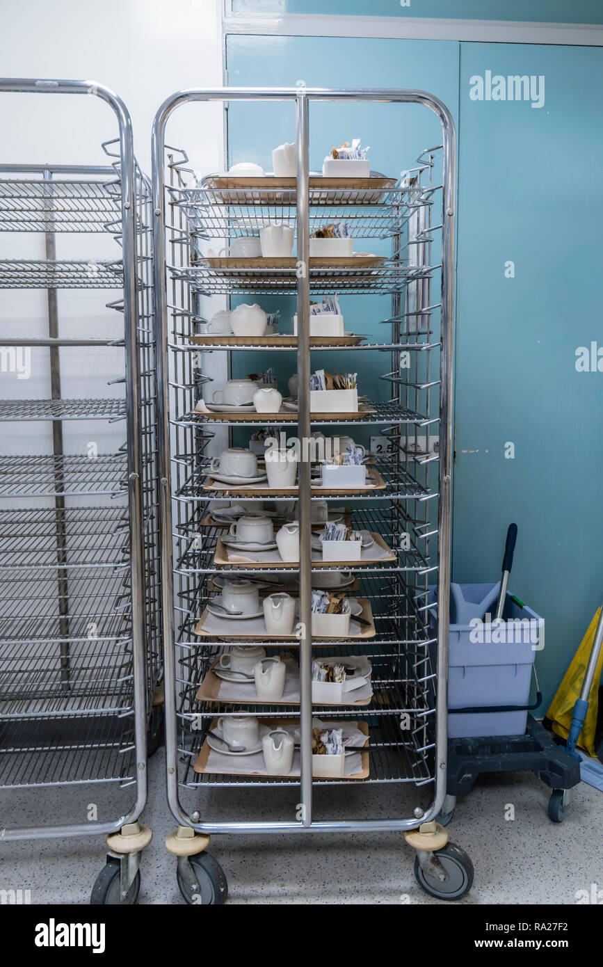 Trolley holding trays made up for evening tea with cups, saucers, jugs ...