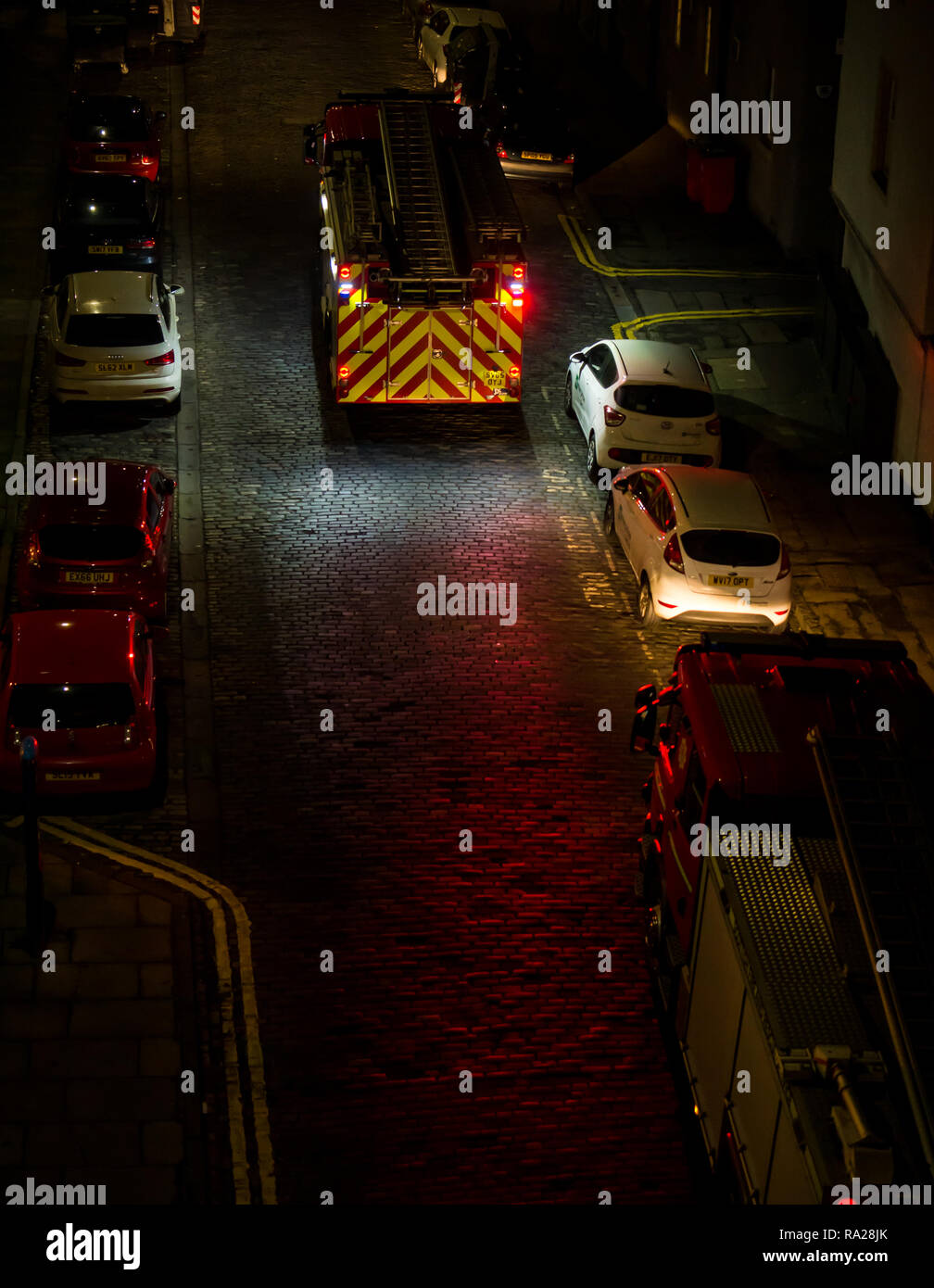 Fire engines with blue flashing lights at night attending fire alarm ...