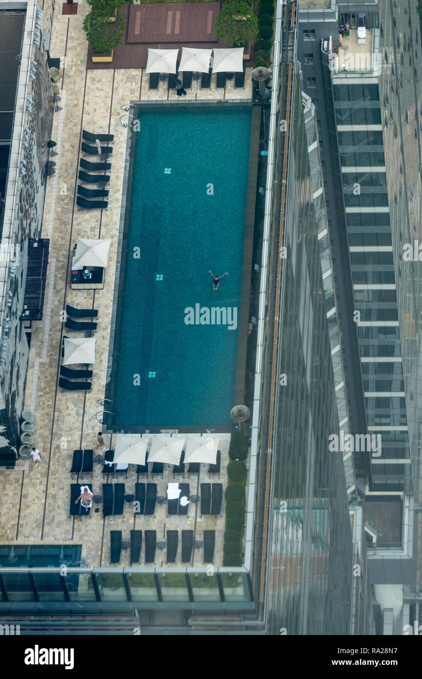 A lone swimmer does lengths in a high rise swimming pool on the roof of ...