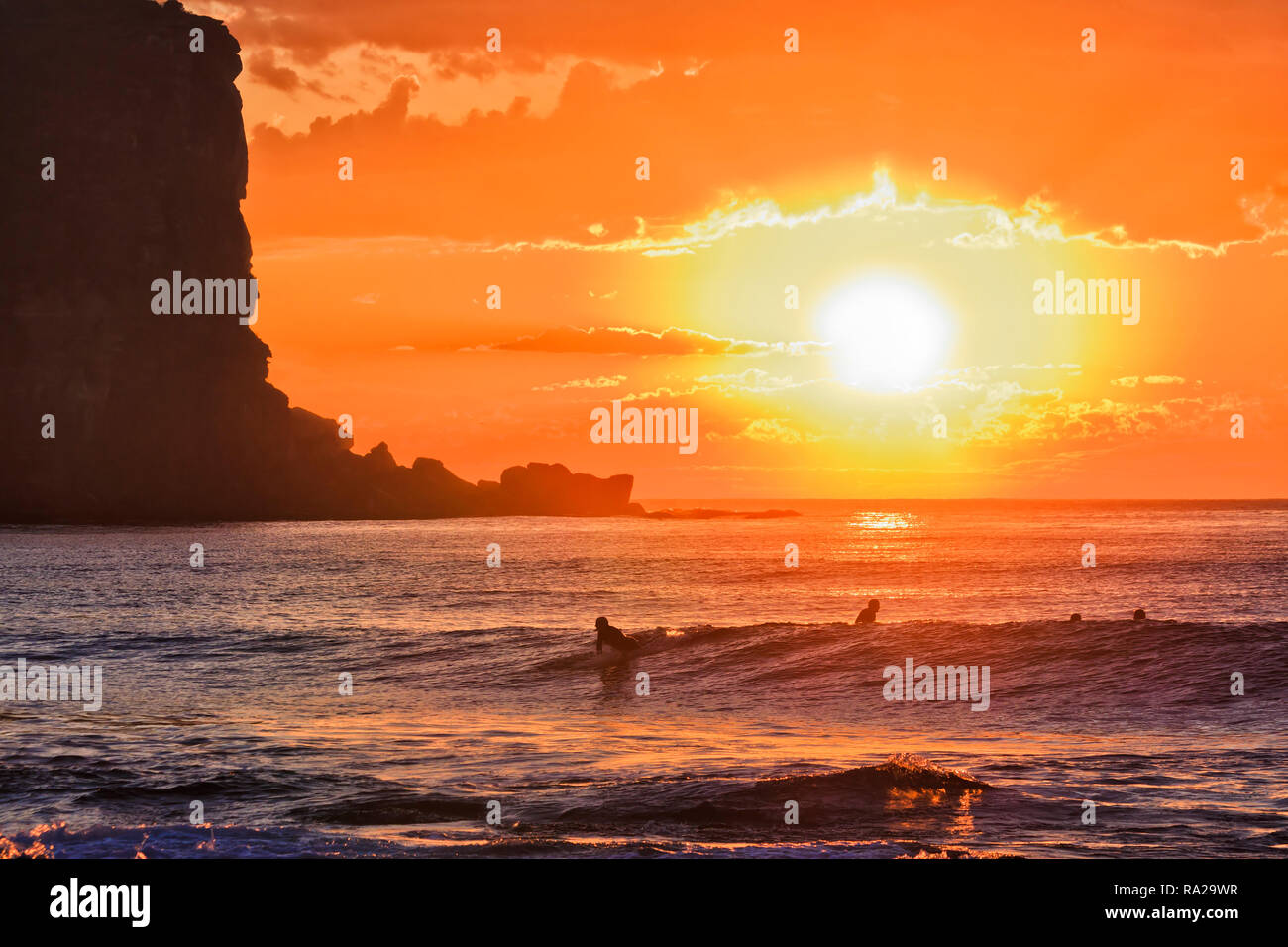 Bloody orange sun over sea horizon flooding rolling waves with ...