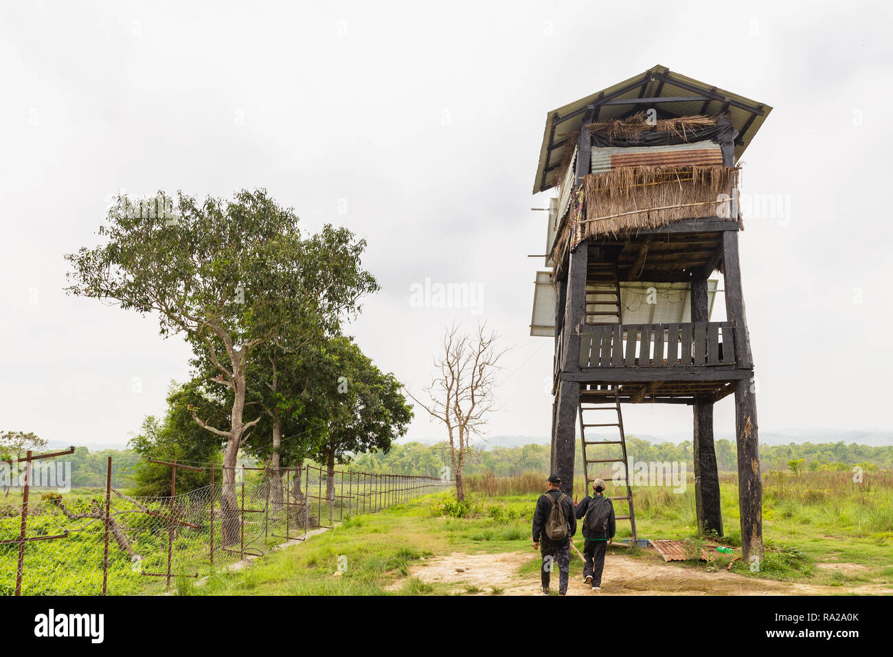 Two Nepali men walking towards the tall viewing and resting platform in ...