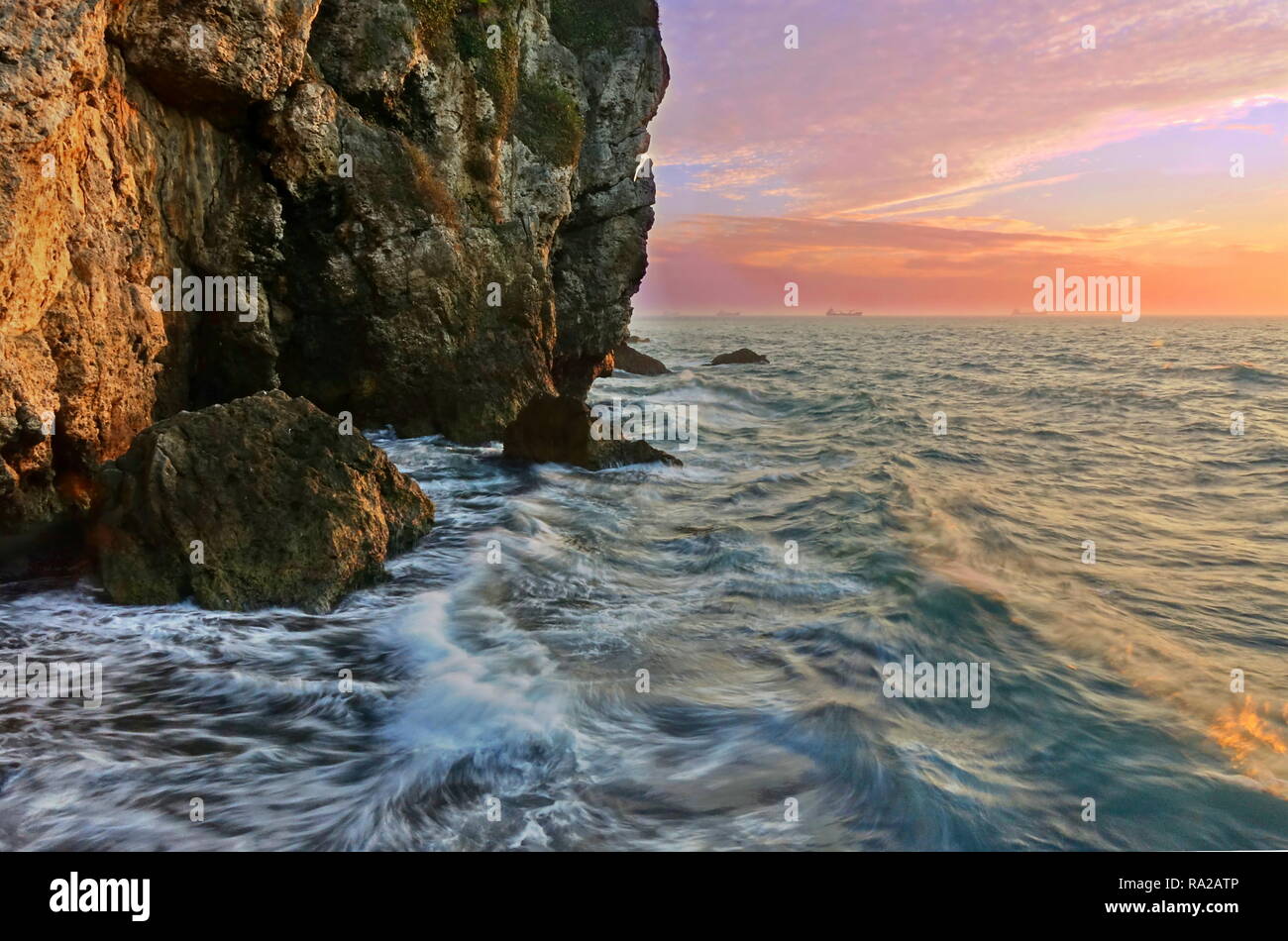 Beautiful rugged cliffs with waves and sunset sky and golden hour Stock ...