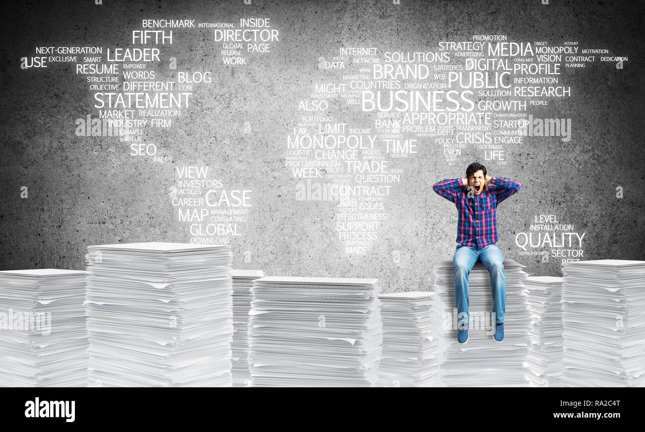 Attractive man sitting on pile of paper documents Stock Photo - Alamy