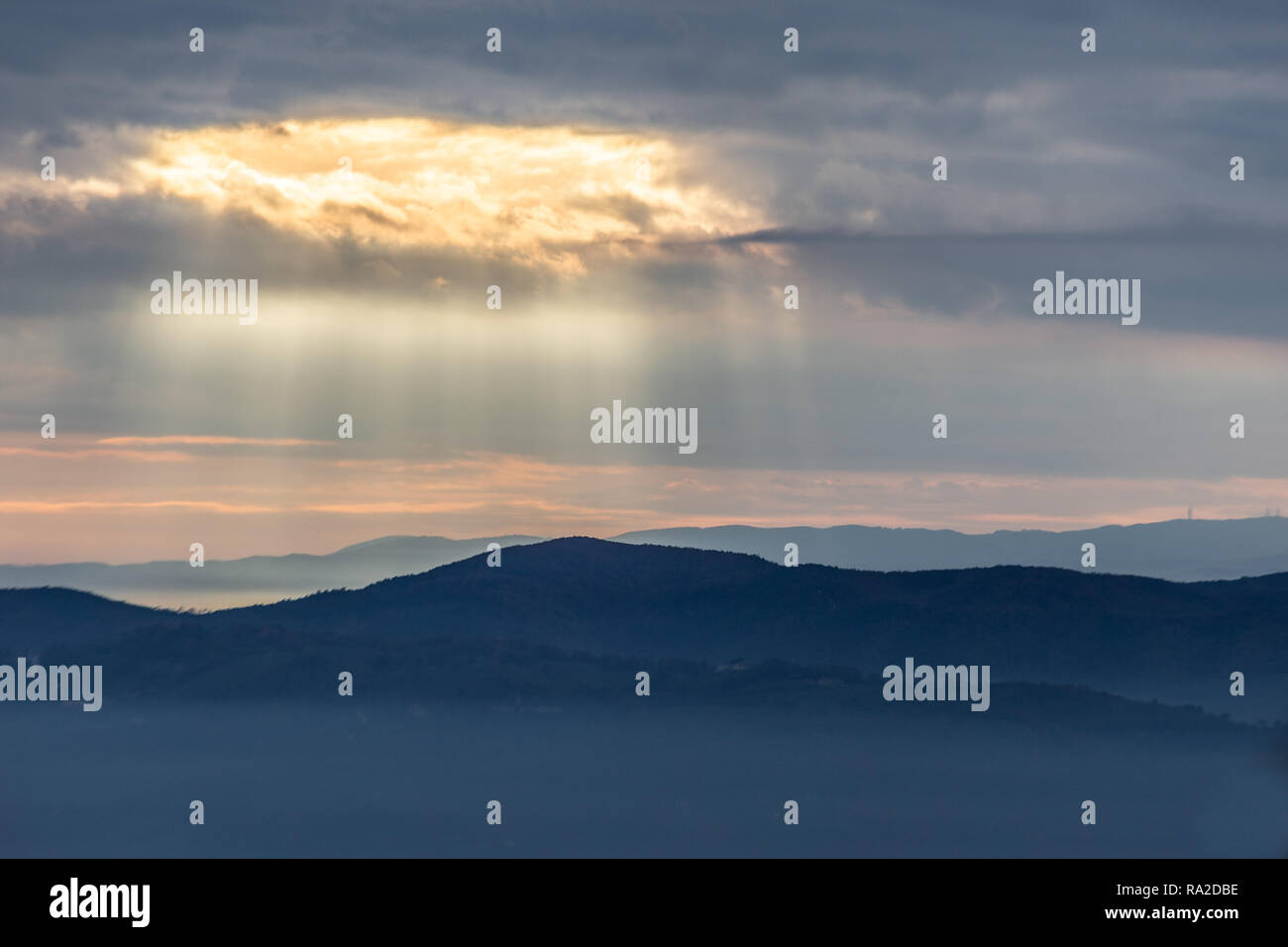 Sunray shines through clouds over the mountains and a sea of fog Stock ...