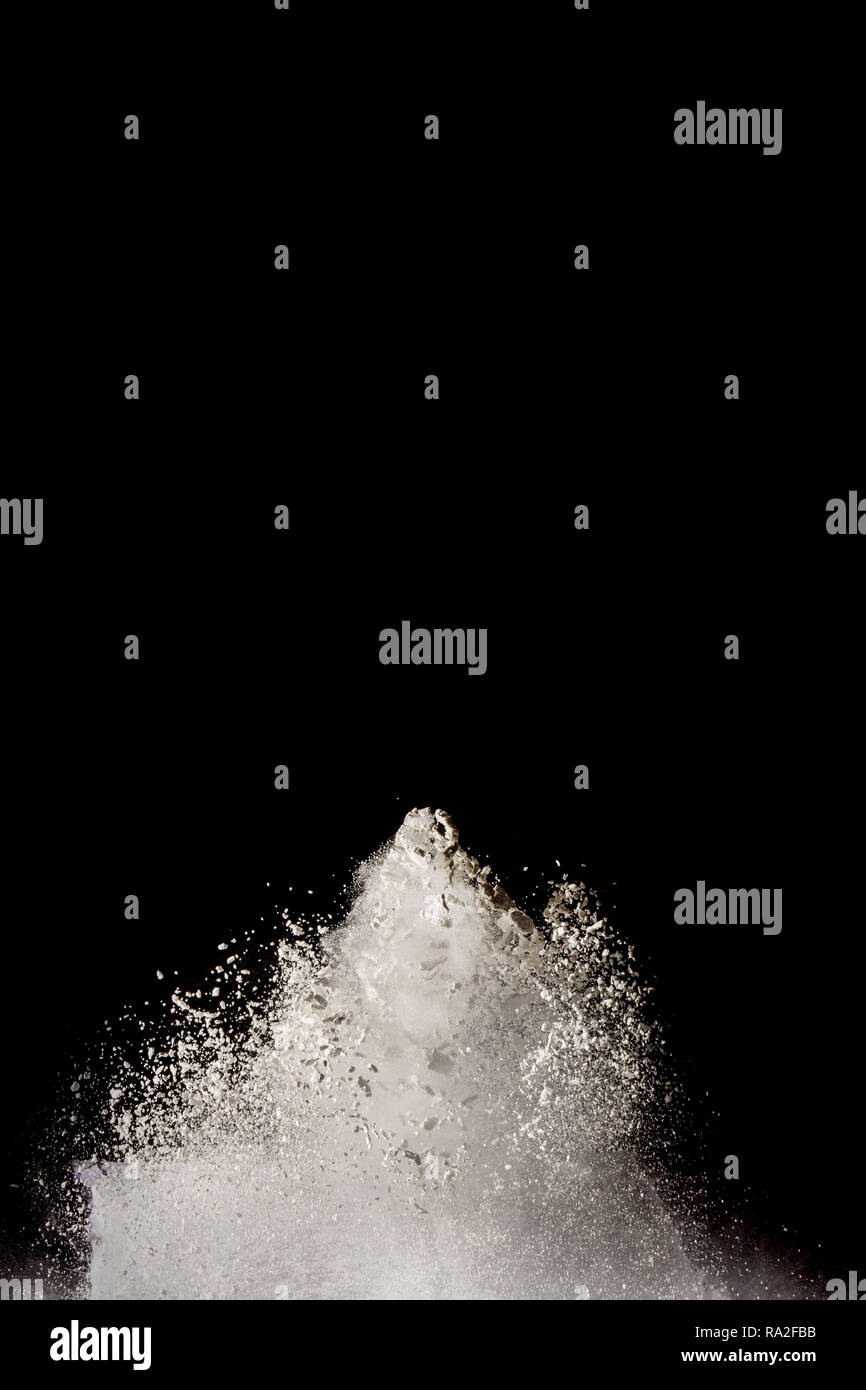 Bizarre forms of white powder explosion cloud against black background ...