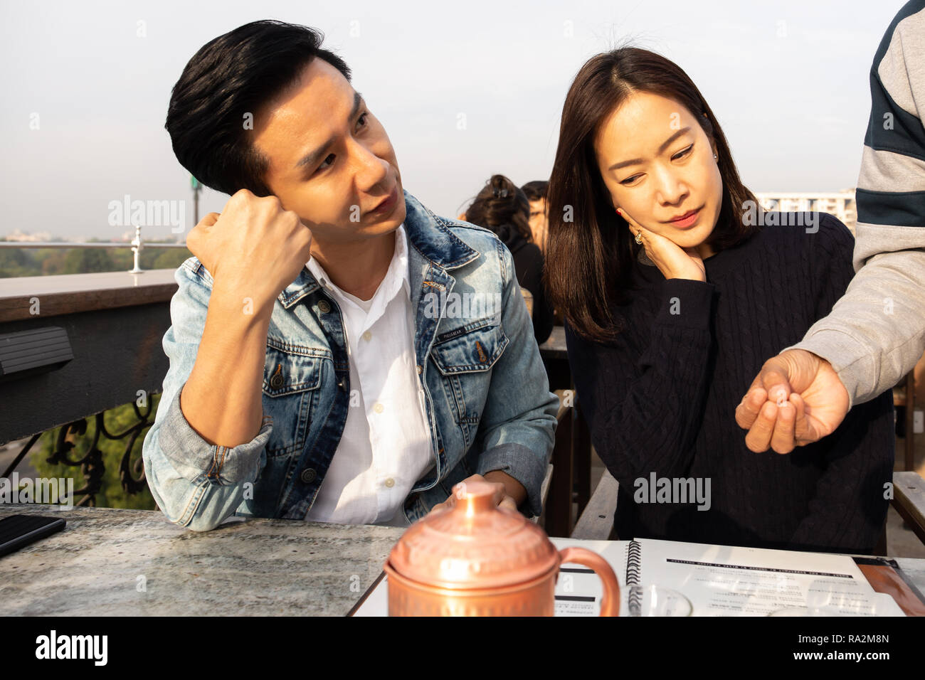 Waiter talking with the couple clients before serving tea and food at ...