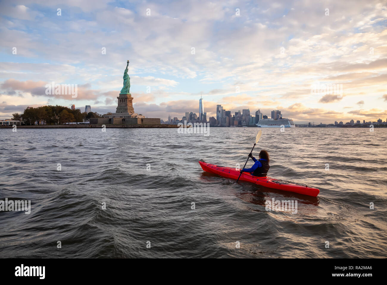 Adventurous Girl Sea Kayaking near the Statue of Liberty during a ...