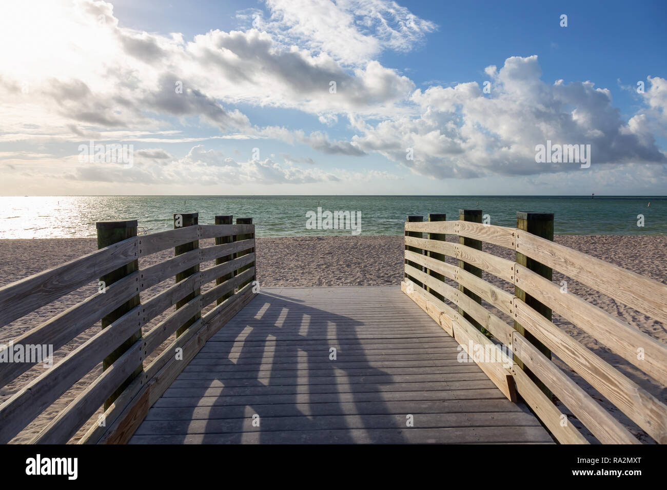 Wooden platform on a sandy beach during a vibrant sunny day. Taken in ...