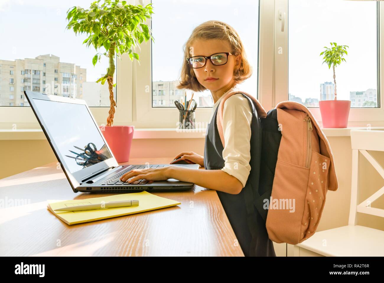Little student girl of 8 years old in school uniform with a backpack ...