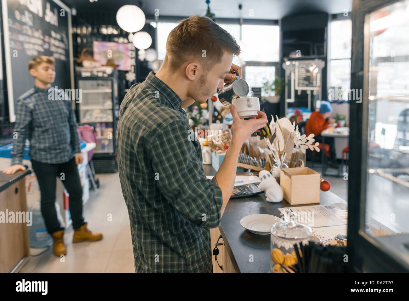 Modern coffee shop, working making coffee barista, people sitting at ...