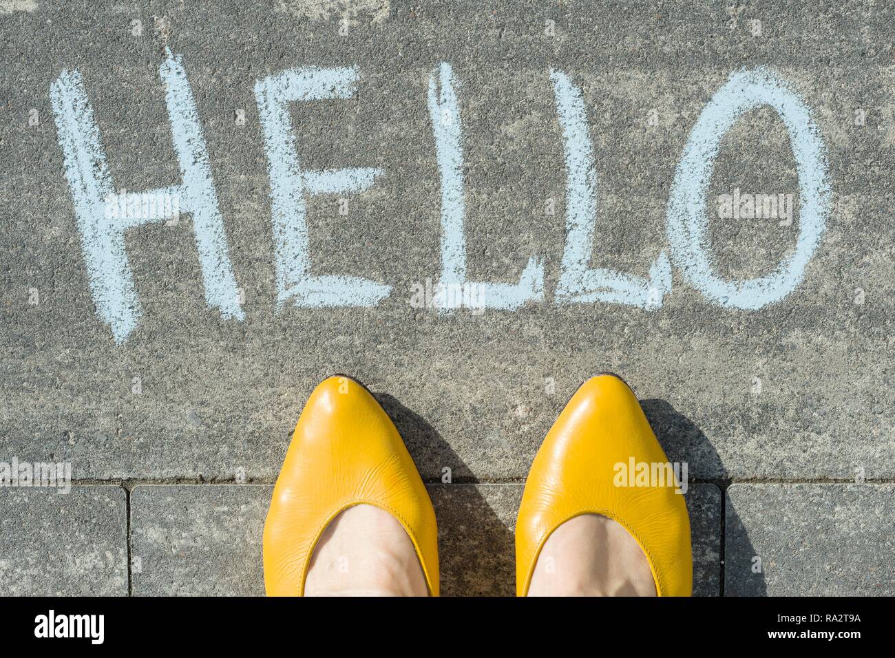 Female feet with text hello written on asphalt Stock Photo - Alamy